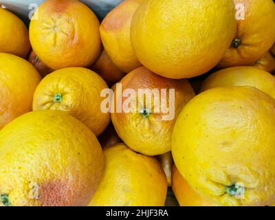 selective focus of pile of oranges in metal basket on blurred ...