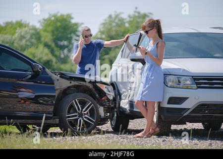 Angry woman and man drivers of heavily damaged vehicles arguing who is ...