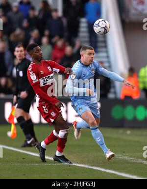 Coventry City's Jake Bidwell (right) crosses the ball under pressure ...