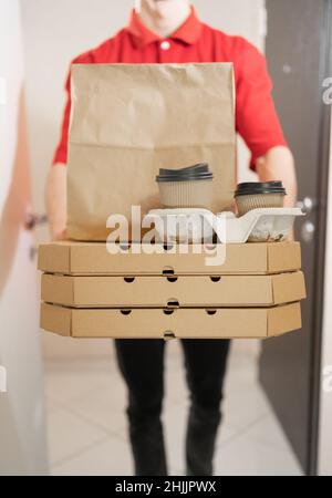 Young courier delivering pizza to the office Stock Photo - Alamy
