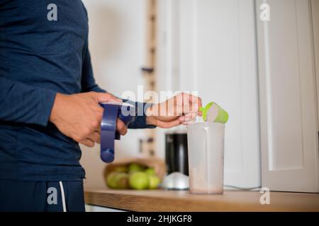Fit male making himself a protein shake at home Stock Photo - Alamy