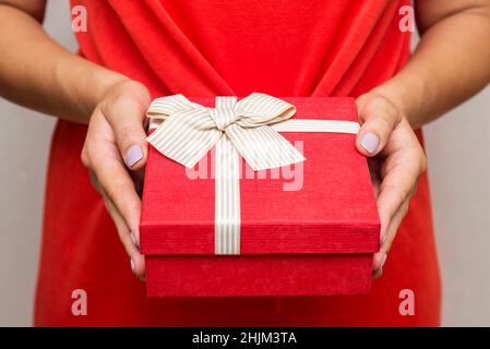 A woman holds a small red object up to her face Stock Photo - Alamy