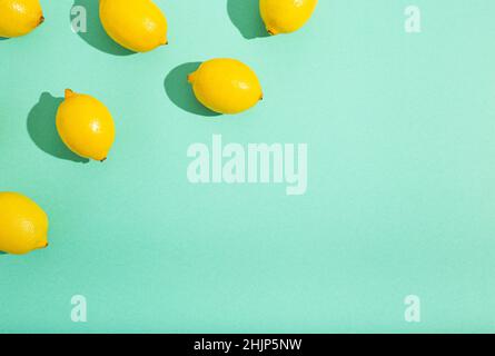 Yellow whole lemons on minimal blue background on bright sun light with ...