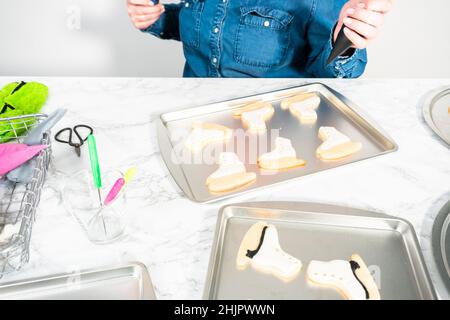 Decorating sugar cookies shaped as figure skates with royal icing Stock ...