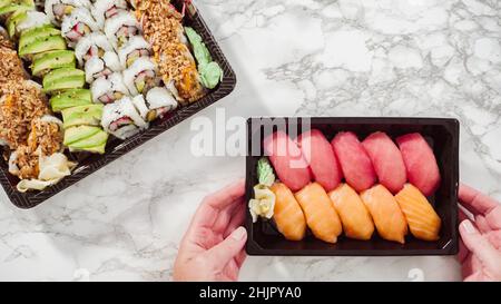 Flat lay. Pre-packaged variety of sushi and sushi rolls in a plastic ...