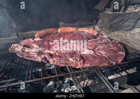 Typical Uruguayan and Argentine Asado Cooked on fire. Entrana and Vacio ...