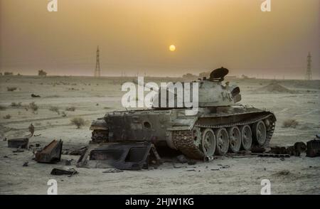 A destroyed Iraqi T-55 main battle tank stands in the sand at Jalibah ...