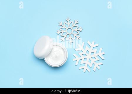 Jar with cream and snowflakes on color background Stock Photo - Alamy