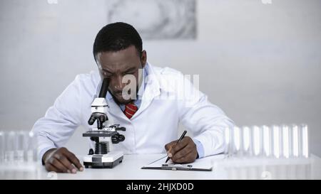 African american man scientist writing on document at laboratory Stock ...