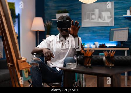Young man artist using virtual reality goggles drawing at art studio ...