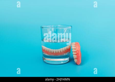 Prosthesis in a glass with a solution. Dental prosthesis care. Full ...
