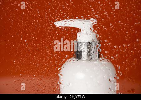 Unbranded brown plastic spray bottle on glass podium and brown herbs ...