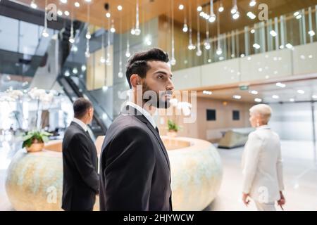 bi-racial bodyguard looking away near senior businesswoman and african ...