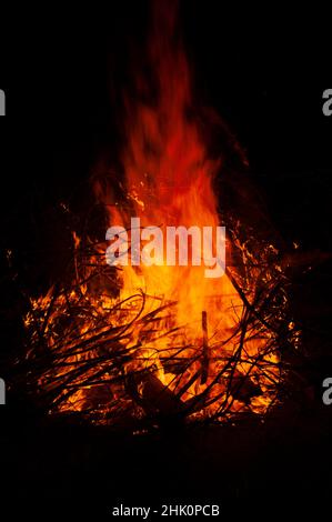 Lit bonfire with wood on black background Stock Photo - Alamy