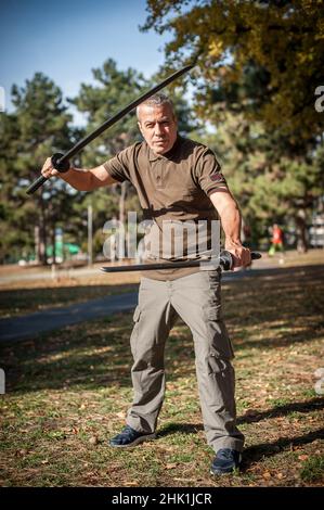 Instructor demonstrates katana sword fighting techniques and training ...