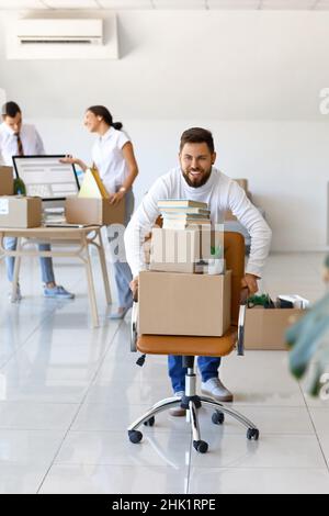 Handsome man near chair with boxes in office on moving day Stock Photo ...