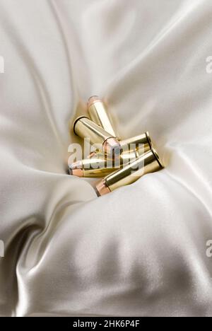 Group of bullets laying on satin pillow Stock Photo - Alamy