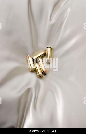 Group of bullets laying on satin pillow Stock Photo - Alamy