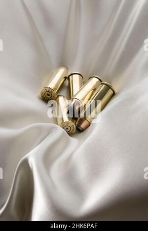 Group of bullets laying on satin pillow Stock Photo - Alamy