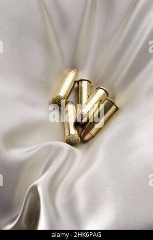 Group of bullets laying on satin pillow Stock Photo - Alamy
