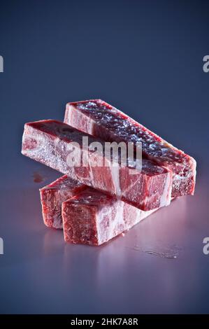 Rectangular cuts of frozen beef stacked on dark background Stock Photo ...