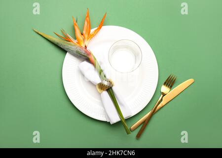 Simple table setting with bird of paradise flower and envelope on white ...