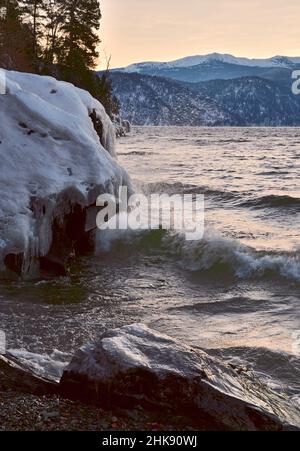Icicles on rocks with pebbles Stock Photo - Alamy