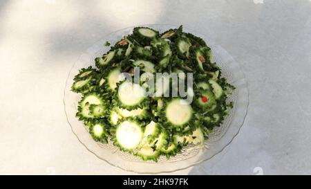 The sliced bitter guard is placed on a plate. With white background ...