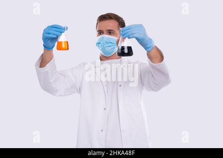 Male Doctor Examing Flask with Colorfull Liquid Wearing Medical Mask ...