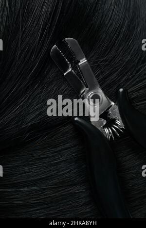 Female hair and hair extension tongs, close up Stock Photo - Alamy