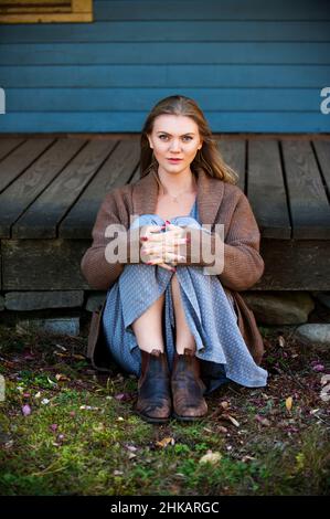 Young woman seated, leaning forward Stock Photo - Alamy