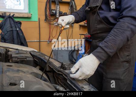 Mechanic checking the oil level in a car engine Stock Photo - Alamy