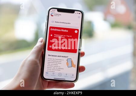 Hand holding an iPhone X with a Corona warn app on the screen Stock ...