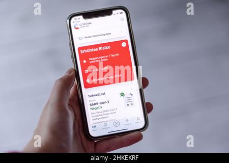 Hand holding an iPhone X with a Corona warn app on the screen Stock ...
