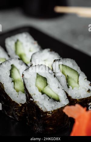 Delicious, juicy and mouth-watering maki with cucumber. Sushi on a gray ...