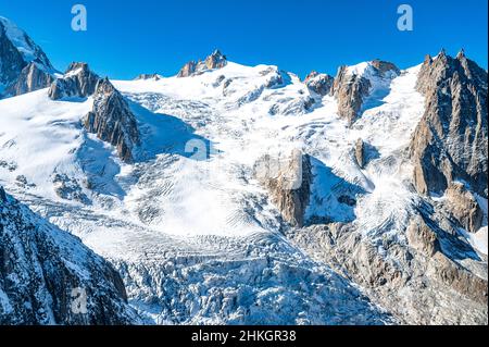 A low angle shot of steep mountain covered in lush greenery under blue ...