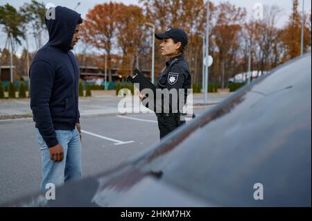 Police woman officer issuing fine to offender Stock Photo - Alamy