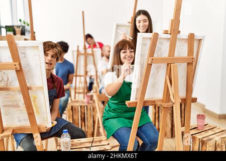 Group of young draw students smiling happy standing with hands together ...