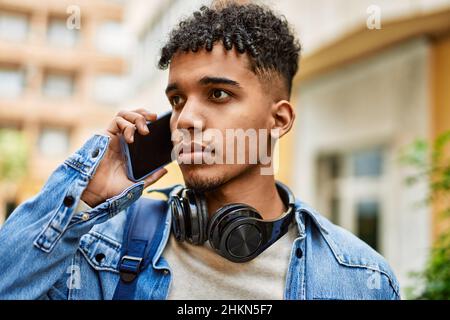 Hispanic young man speaking on the phone at the street Stock Photo - Alamy