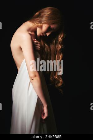 Tragic portrait of the lovely young sad girl against black background ...