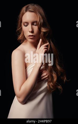 Tragic portrait of the lovely young sad girl against black background ...