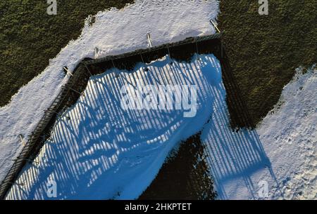 Aitrang, Germany. 05th Feb, 2022. The low sun casts shadows of snow ...