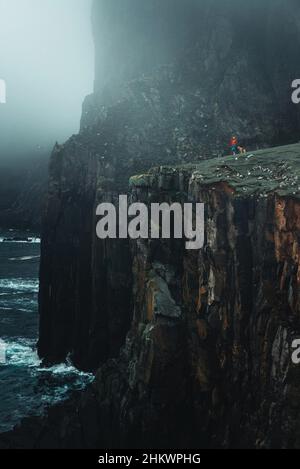Vertical shot of the beautiful massive cliffs on a foggy day. Scotland ...