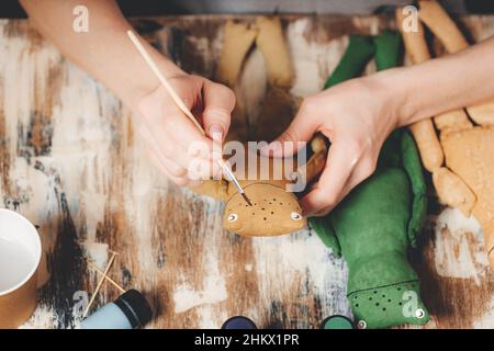 Handmade soft Doll frog. DIY gift crafting. Human hands hold frog soft ...