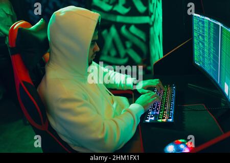Hacker in hoodie working hacks code site on personal computer. War and ...