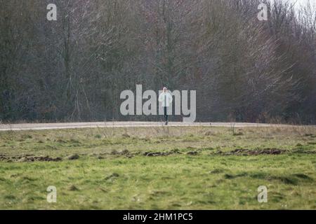 man wearing high visibility socks jogging on an unmade track road Stock ...