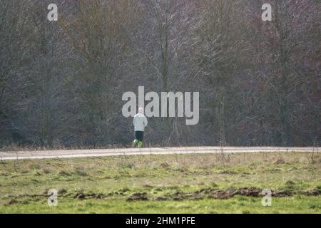 man wearing high visibility socks jogging on an unmade track road Stock ...