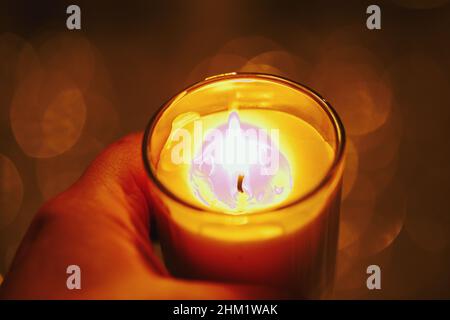 Close-up of a hand cupping a lit candle Stock Photo - Alamy