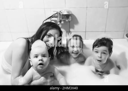 Mom washes the children. Mom and children are taking water procedures ...