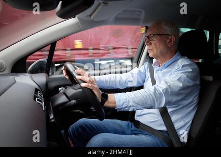 Photograph of an older man driving a right hand drive car, UK Stock ...